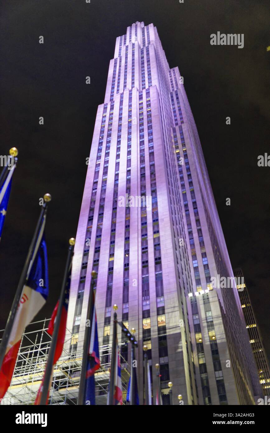 Rockefeller Center, A skyscraper shines in lights at night next to ...