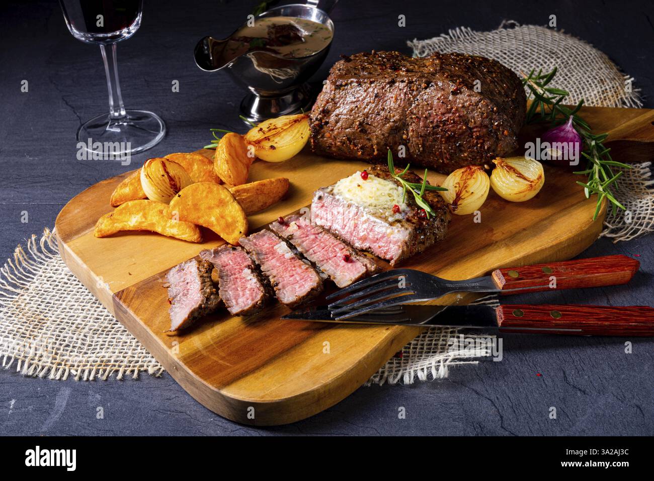 Rustic medium rare beef steak with herbs and potato wedges Stock Photo - Alamy