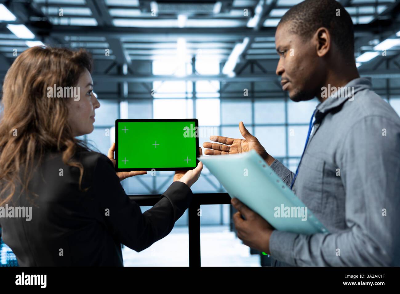 Admins in data center using mockup tablet, observing analytics, reviewing infrastructure health ...
