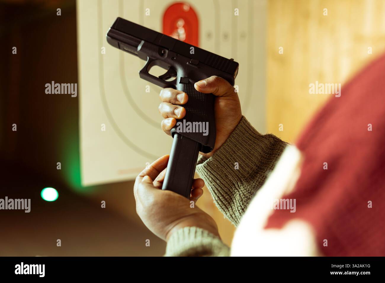 Shooting range customer preparing equipment, reloading handgun magazine ...