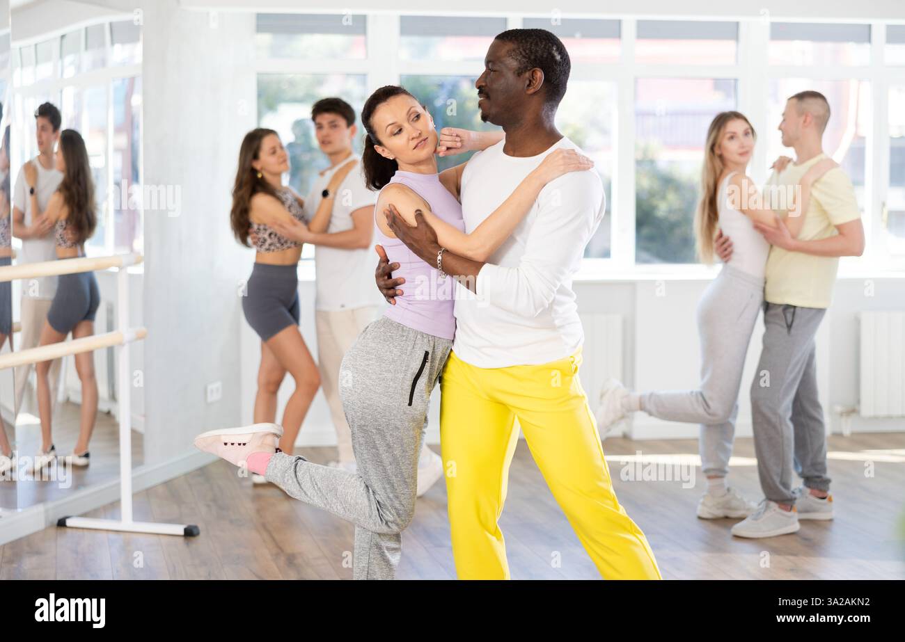 Group of active young multinational people rehearsing paso doble dance ...