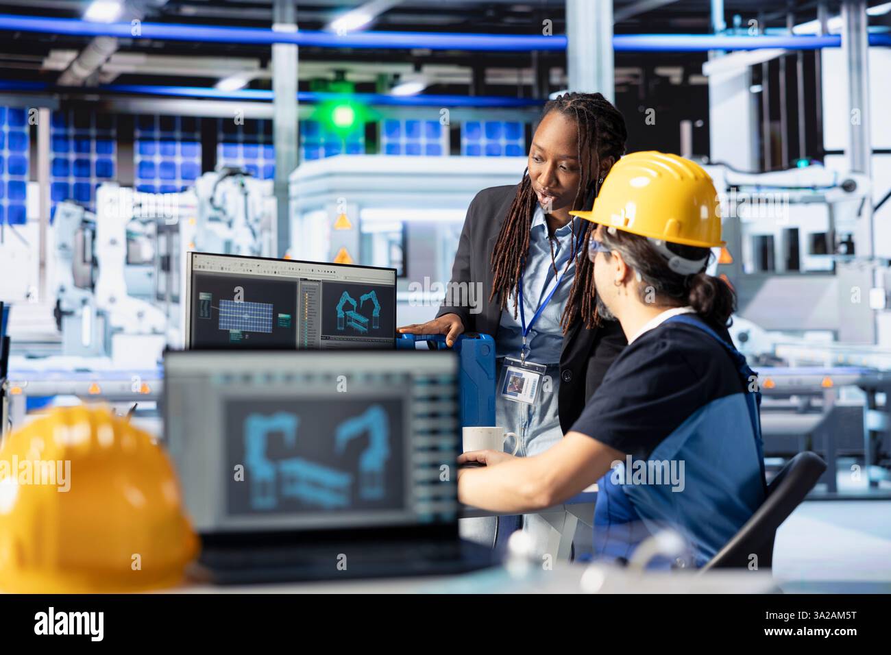 Staff members in photovoltaics factory reviewing system logs to ...