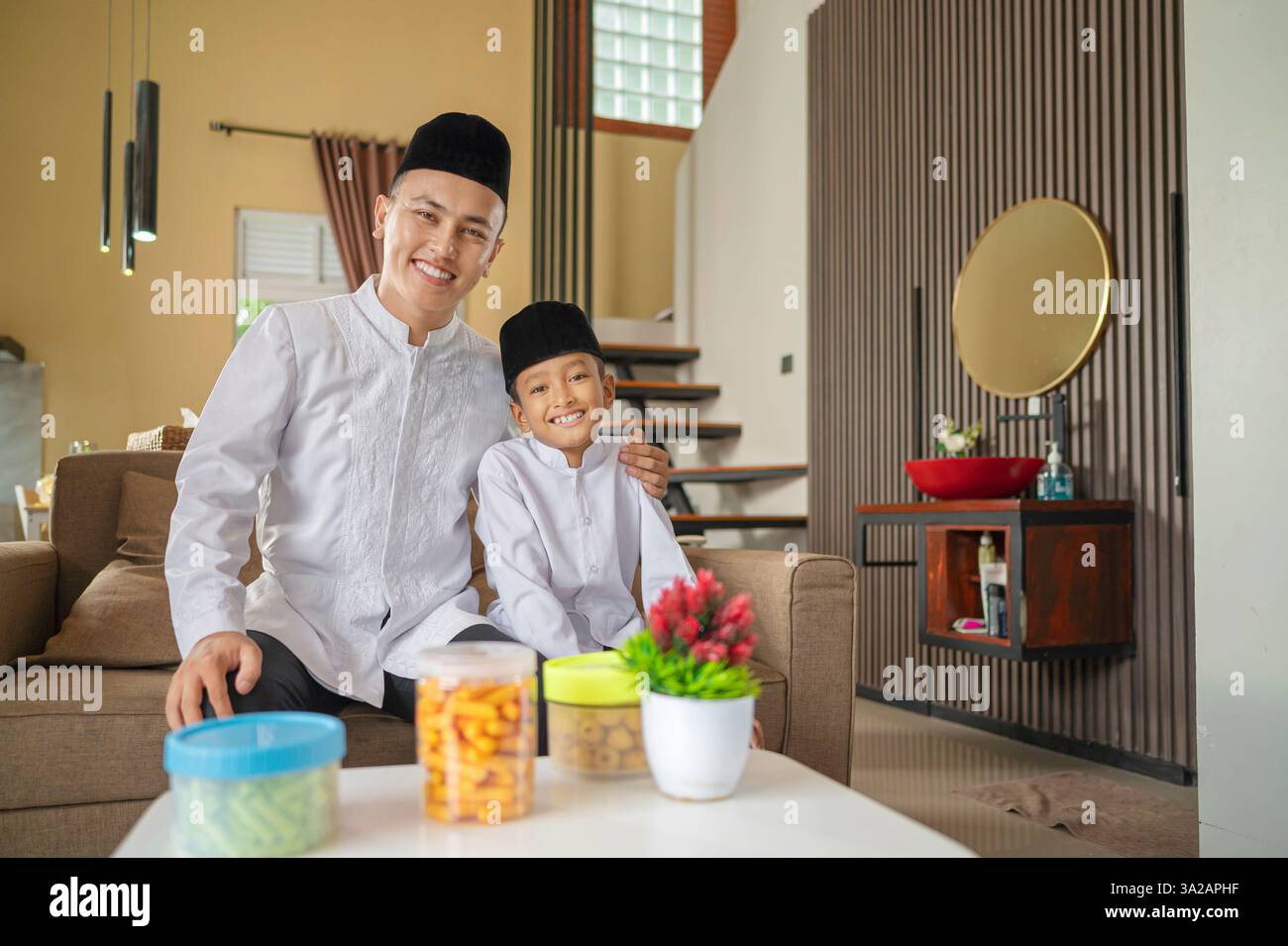 Portrait of the Indonesian Muslim father with his son celebrating Eid Mubarak. Concept of Happy ...