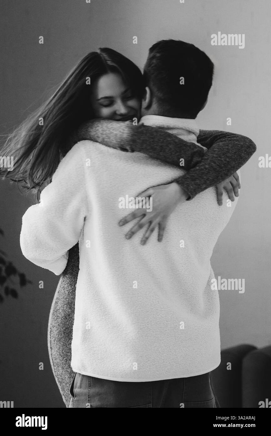 Couple shares an intimate moment while hugging in cozy indoor setting ...