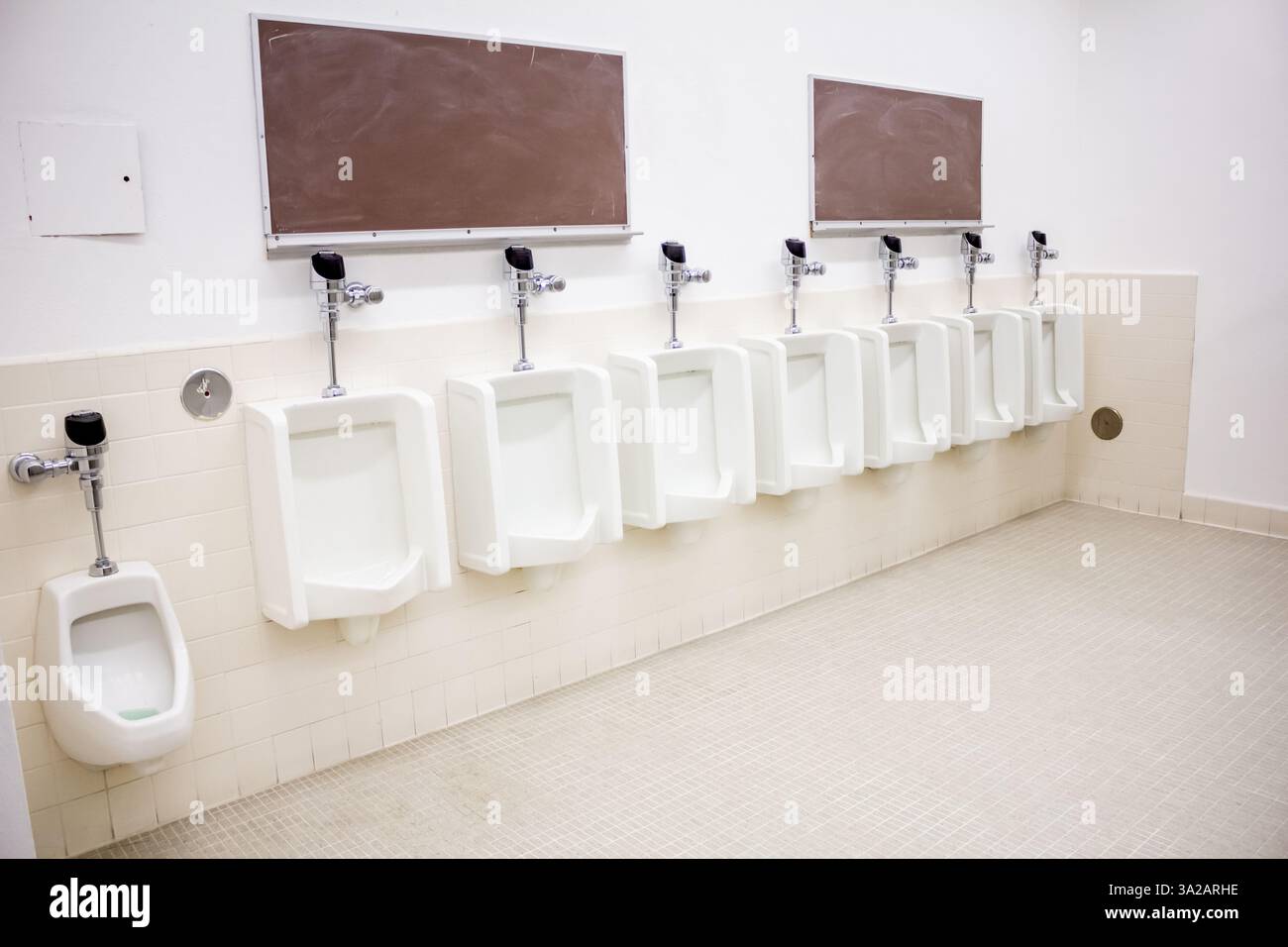 A view of a row of urinals on the wall of a men's public restroom Stock ...