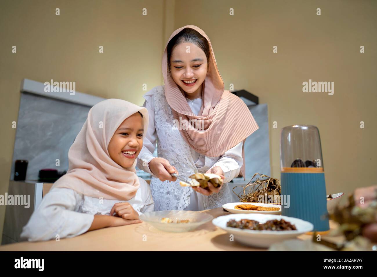 Indonesian Muslim wife serving ketupat rice dumpling for family in the ...