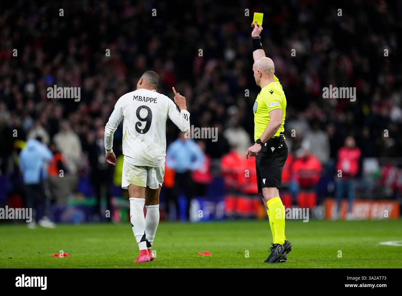 Referee Szymon Marciniak shows a yellow card to Real Madrid's Kylian ...