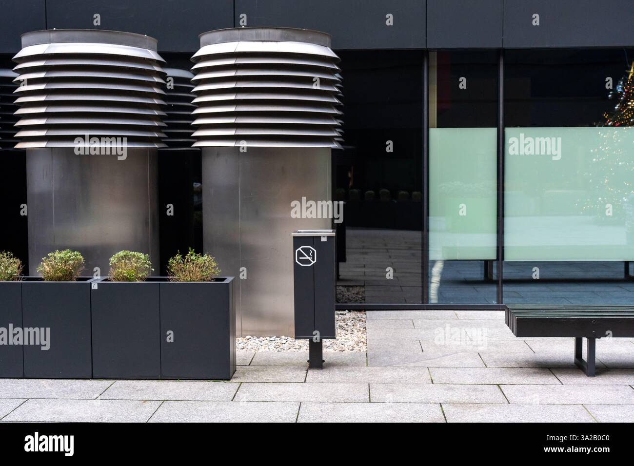 Modern urban smoking area with sleek metal ashtray, bench, and ...