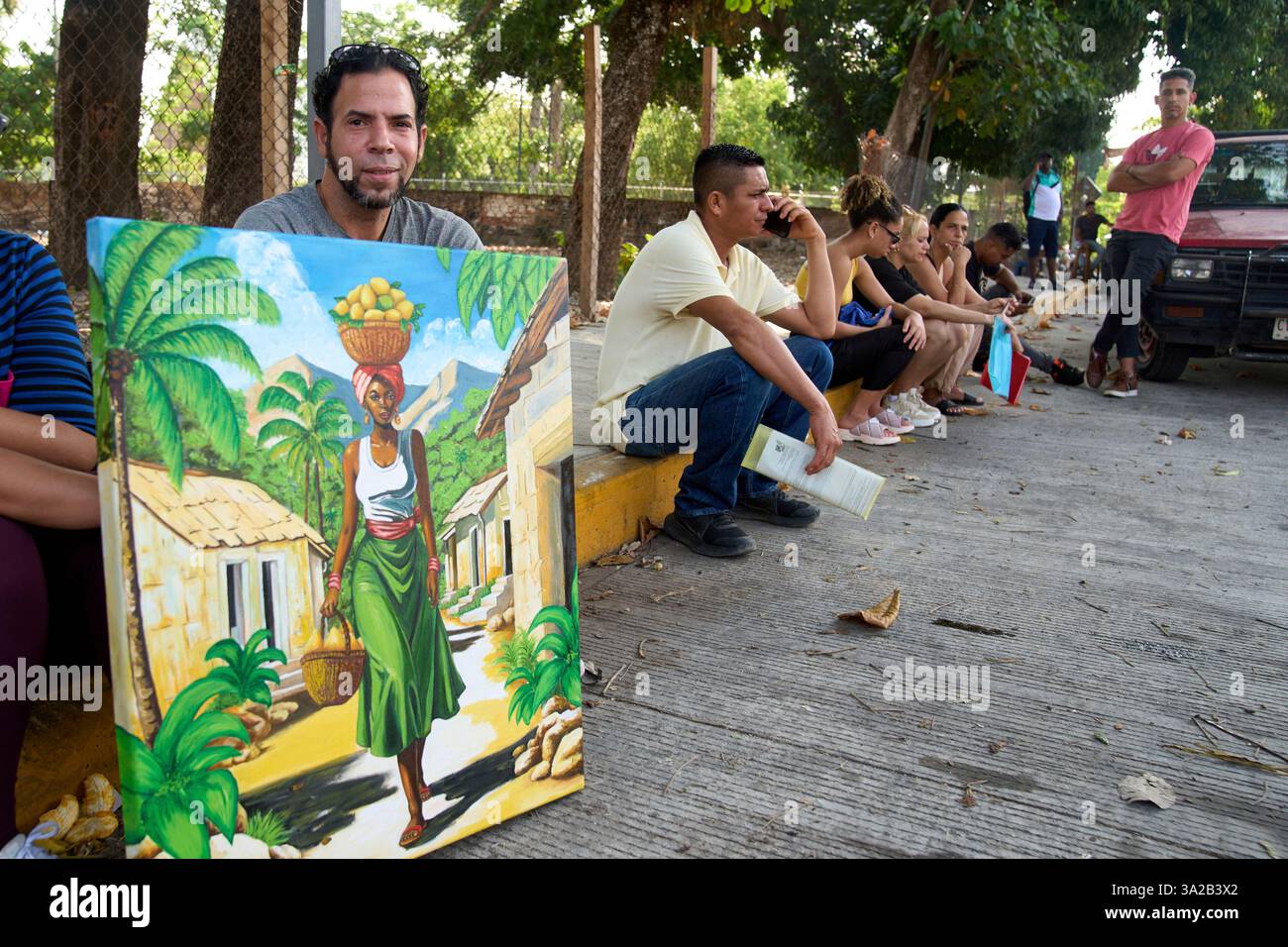 Cuban asylum seeker Junior Rodríguez Santos holds up a piece of art he ...