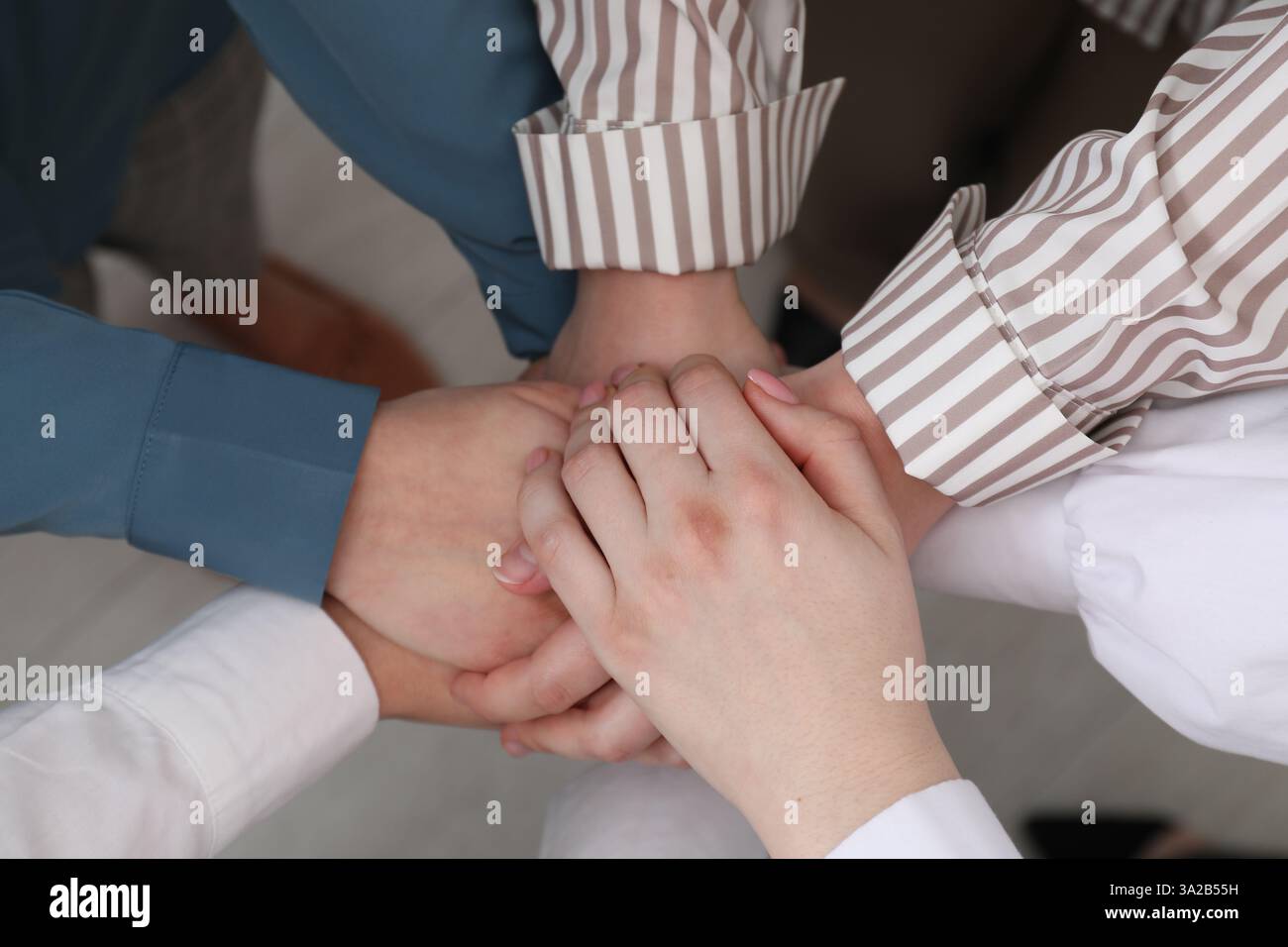 Business concept. Group of people stacking hands indoors, above view ...