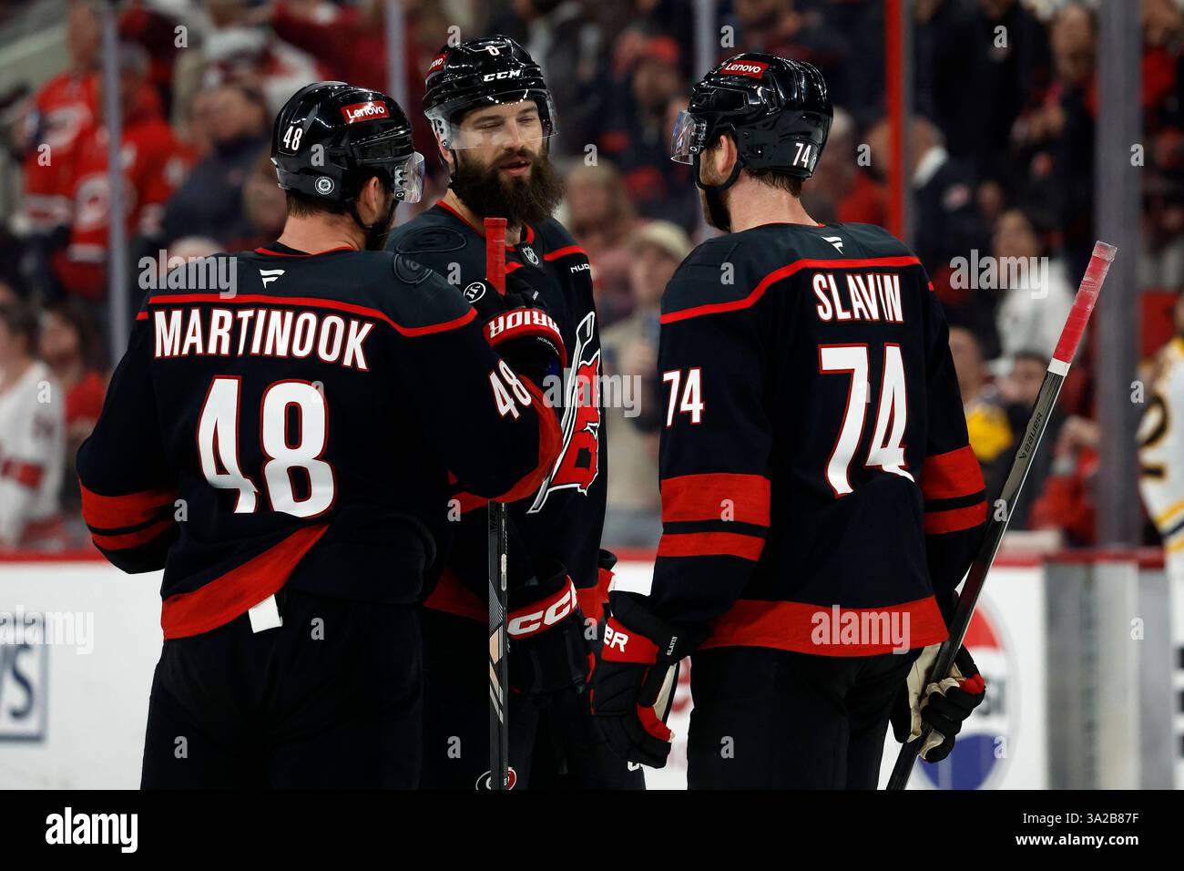 Carolina Hurricanes' Brent Burns, center talks with teammates Jordan ...