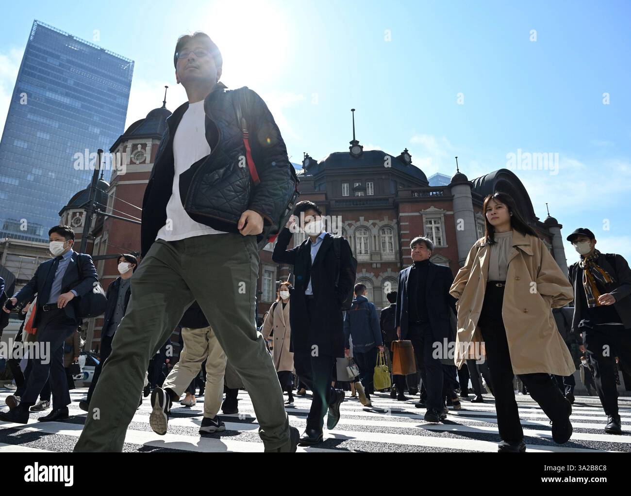 Commuters and others walk in the strong sunlight in near Tokyo Station in Chiyoda Ward, Tokyo ...