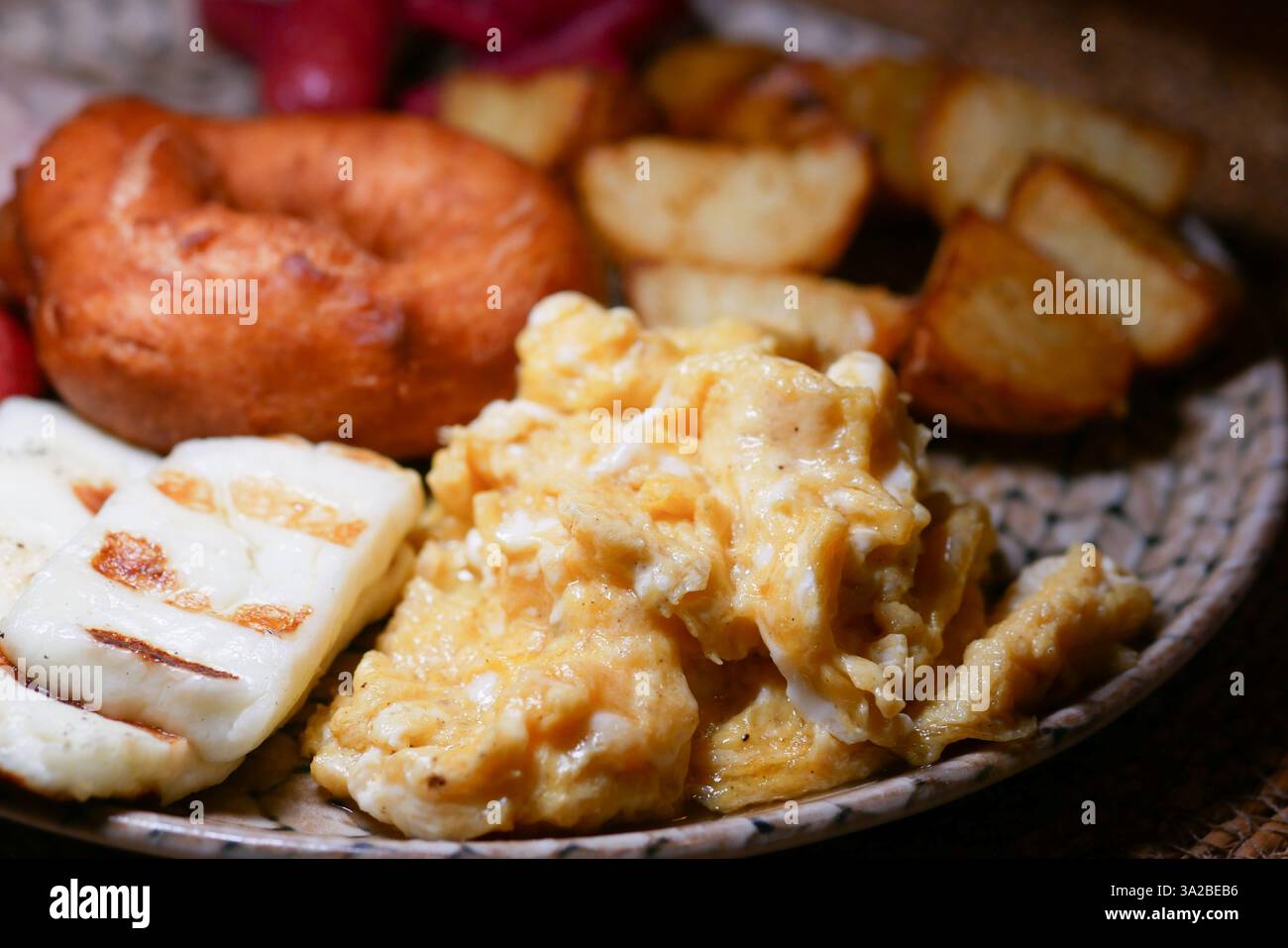 Breakfast spread featuring scrambled eggs, cheese, and pastries Stock ...