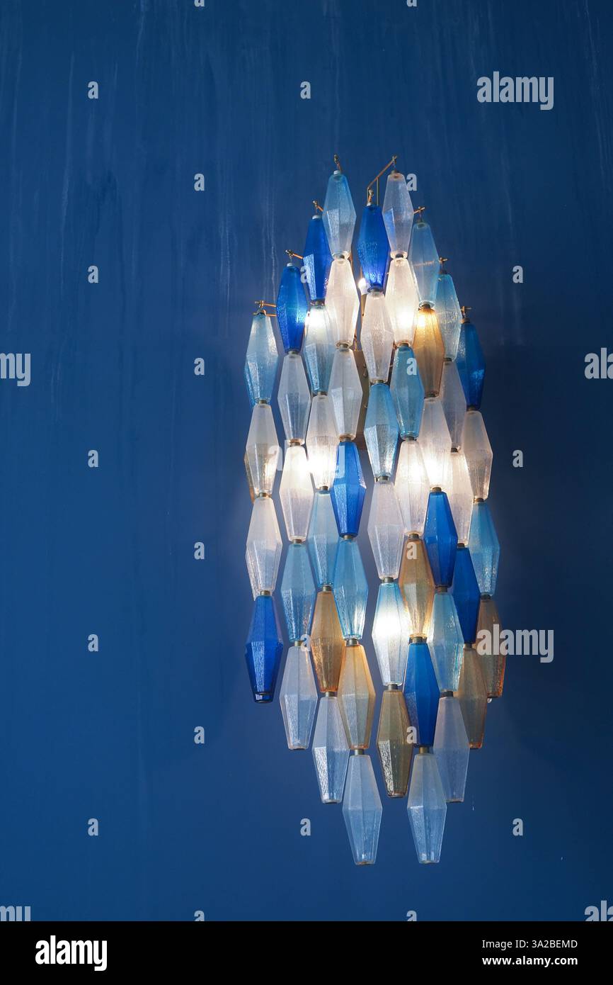 Unique hexagonal light fixture enhances blue wall decor Stock Photo - Alamy