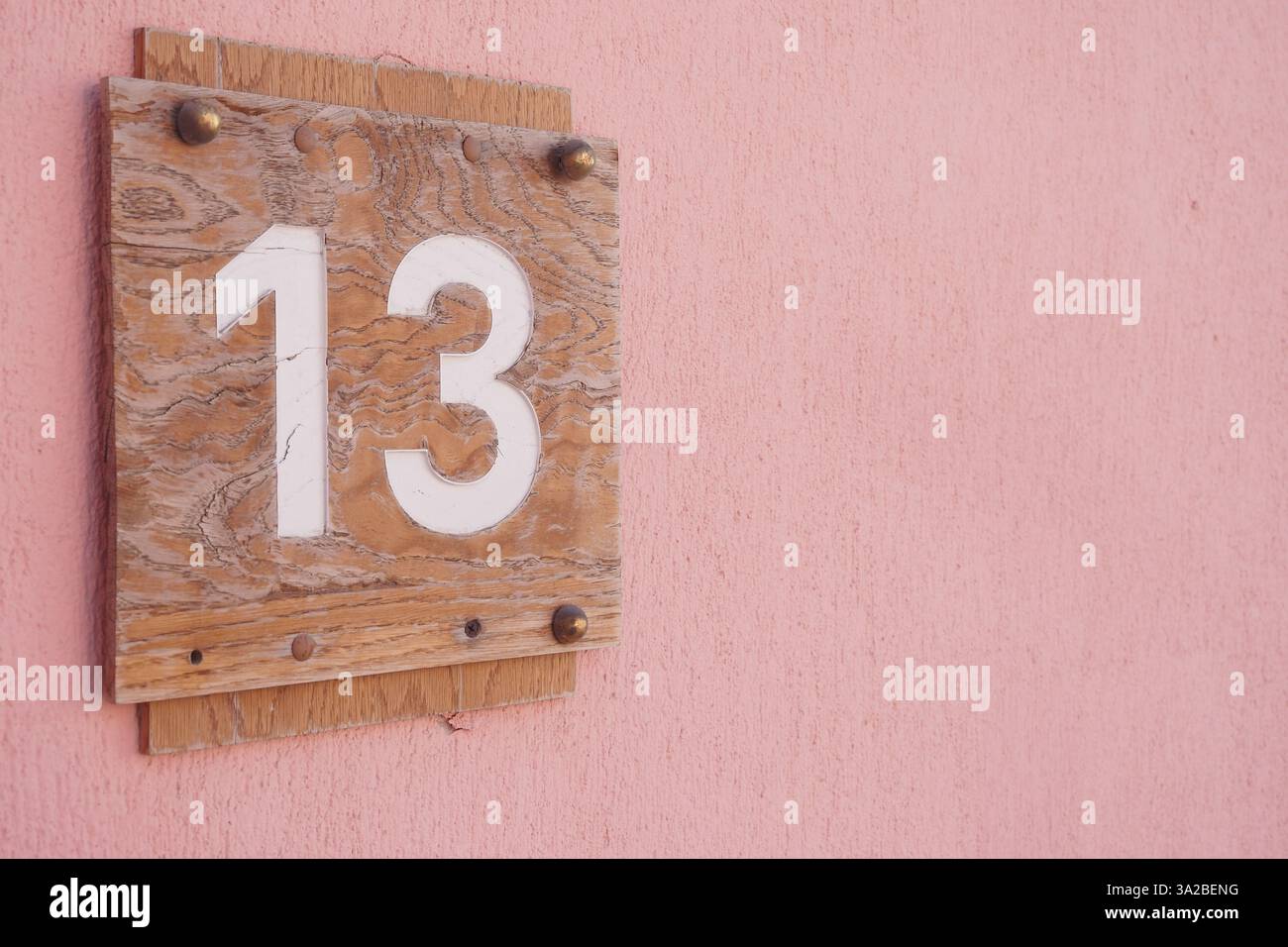Wooden house number 13 on a pink wall in bright sunlight Stock Photo ...