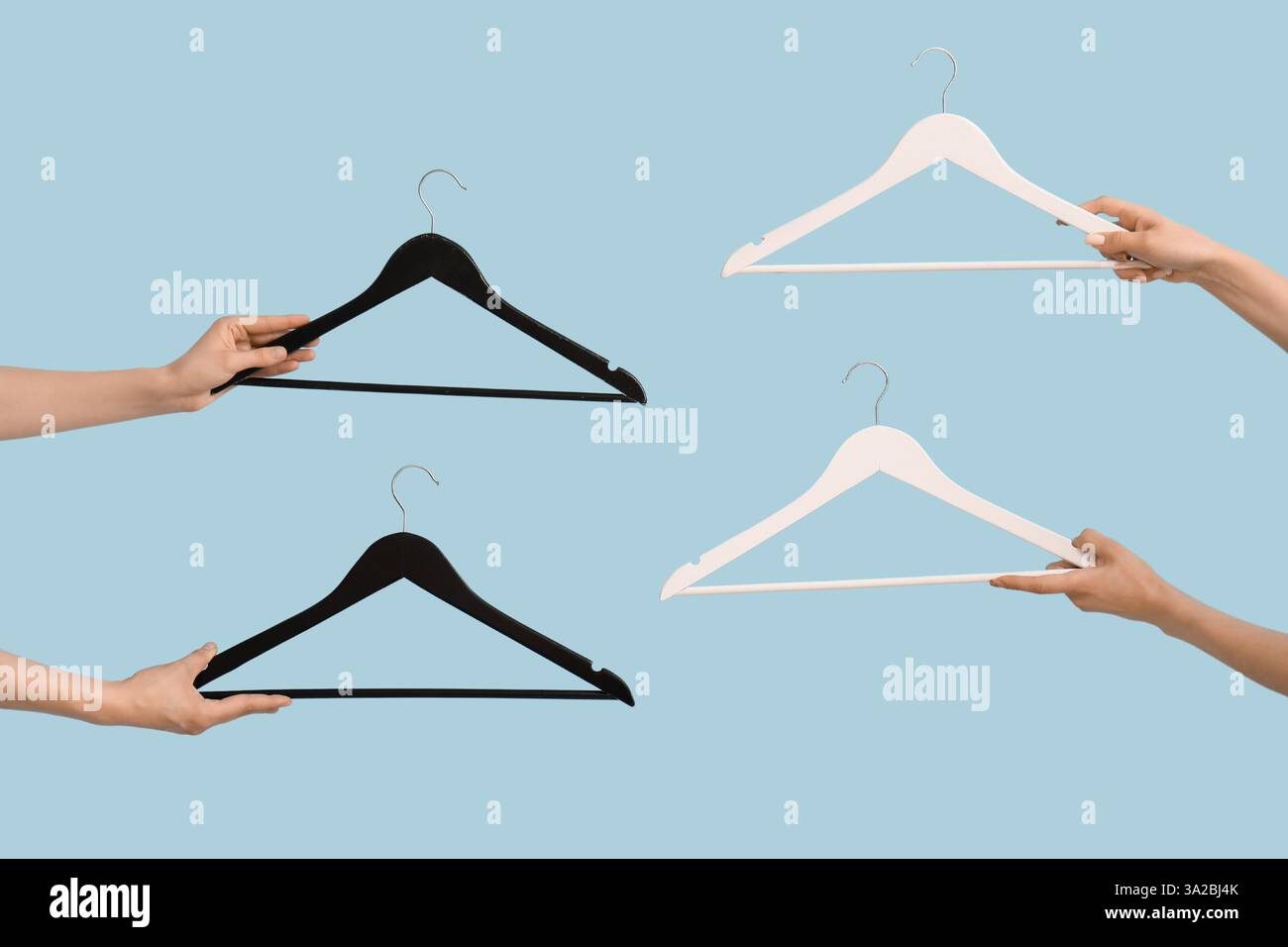 Women holding wooden clothes hangers on blue background Stock Photo - Alamy