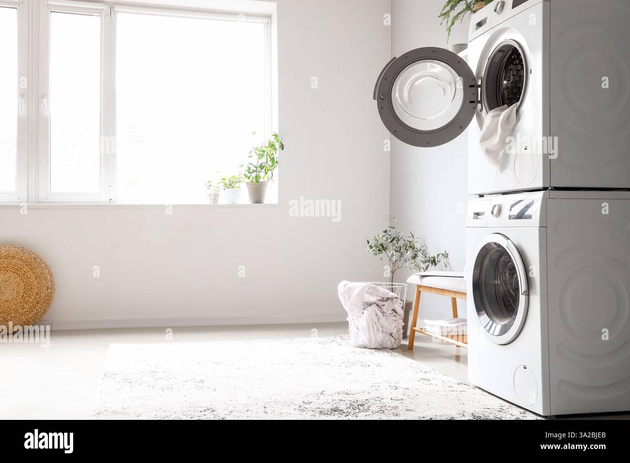 Interior of modern laundry room with washing machines and grey bench ...