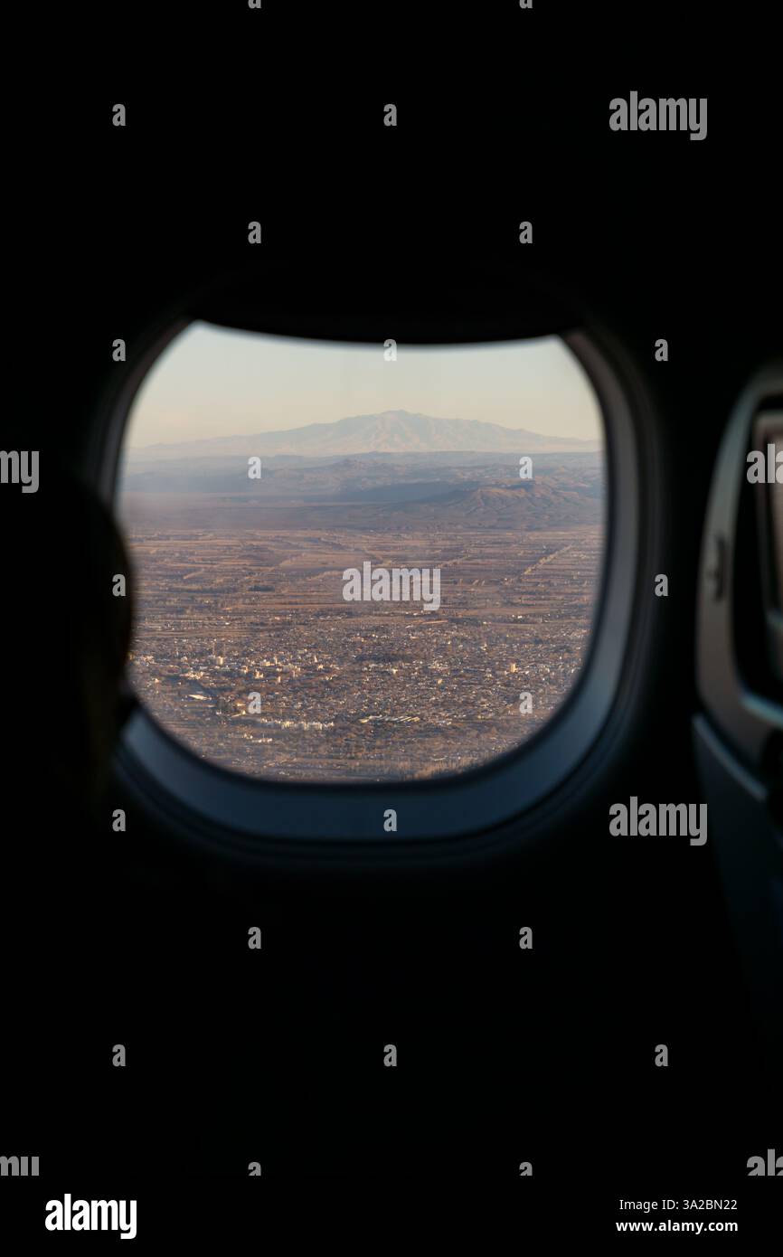 Small city through a window of a plane. Big mountain behind Stock Photo ...