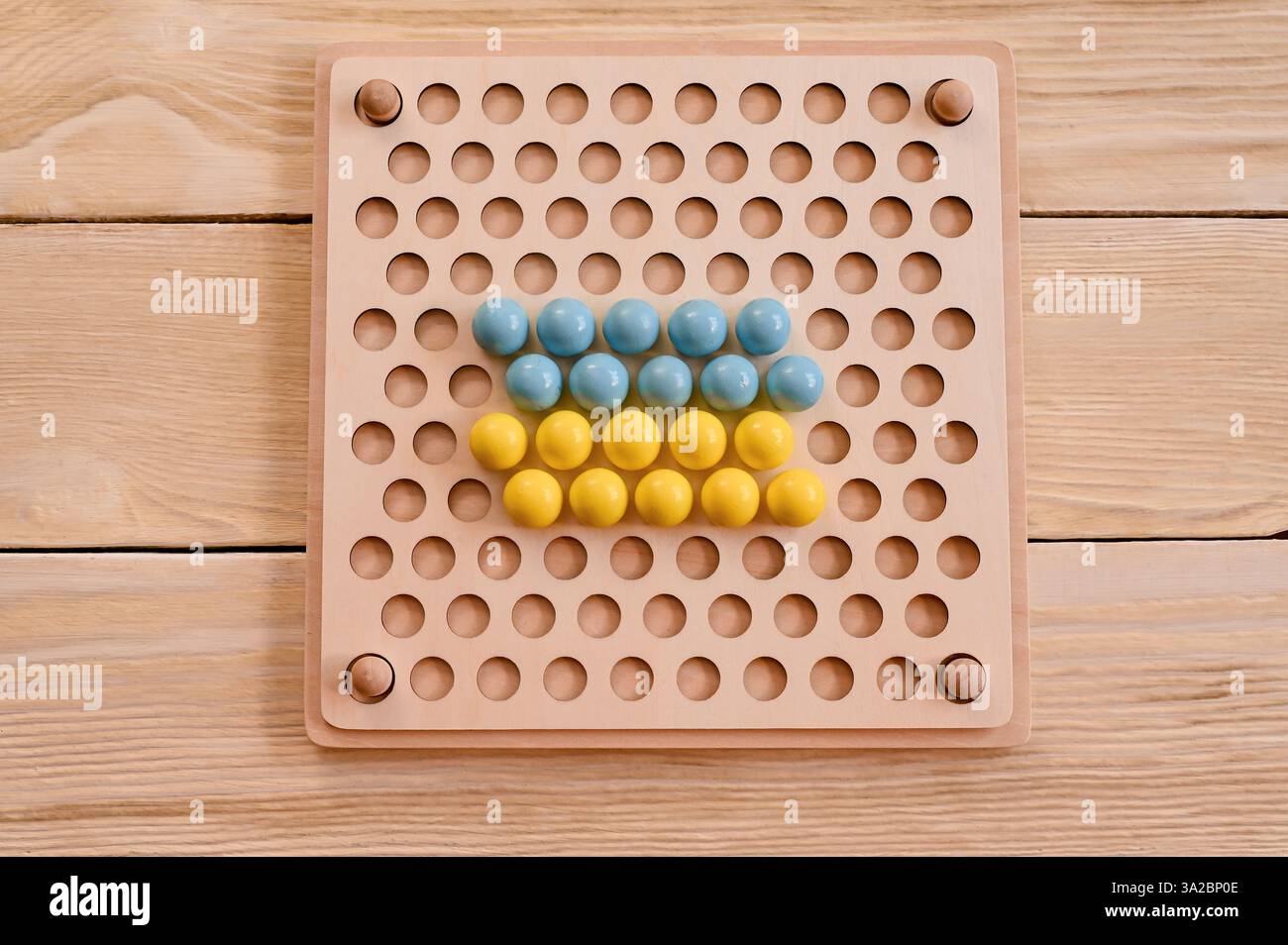 A wooden Montessori game with yellow-blue balls. Develop fine motor ...