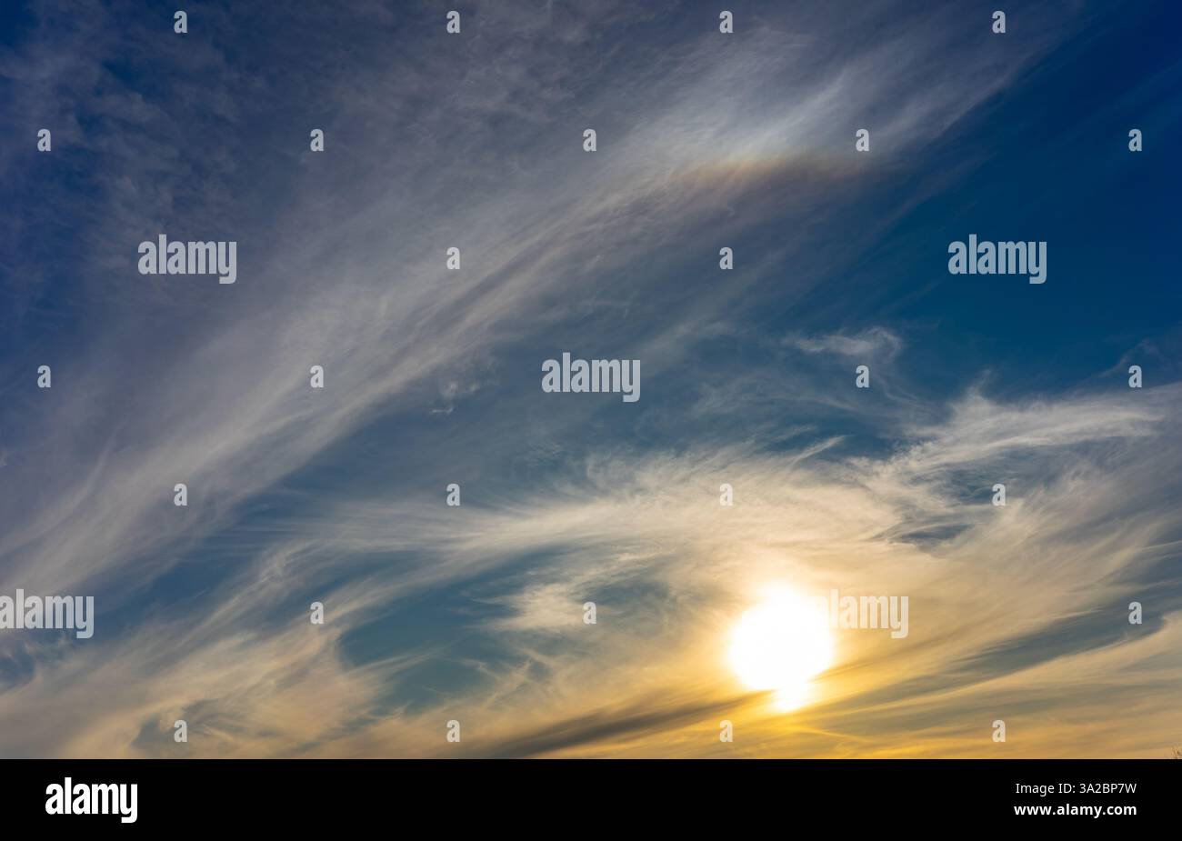 Bright clouds in various hues fill the sky at sunset, creating a ...