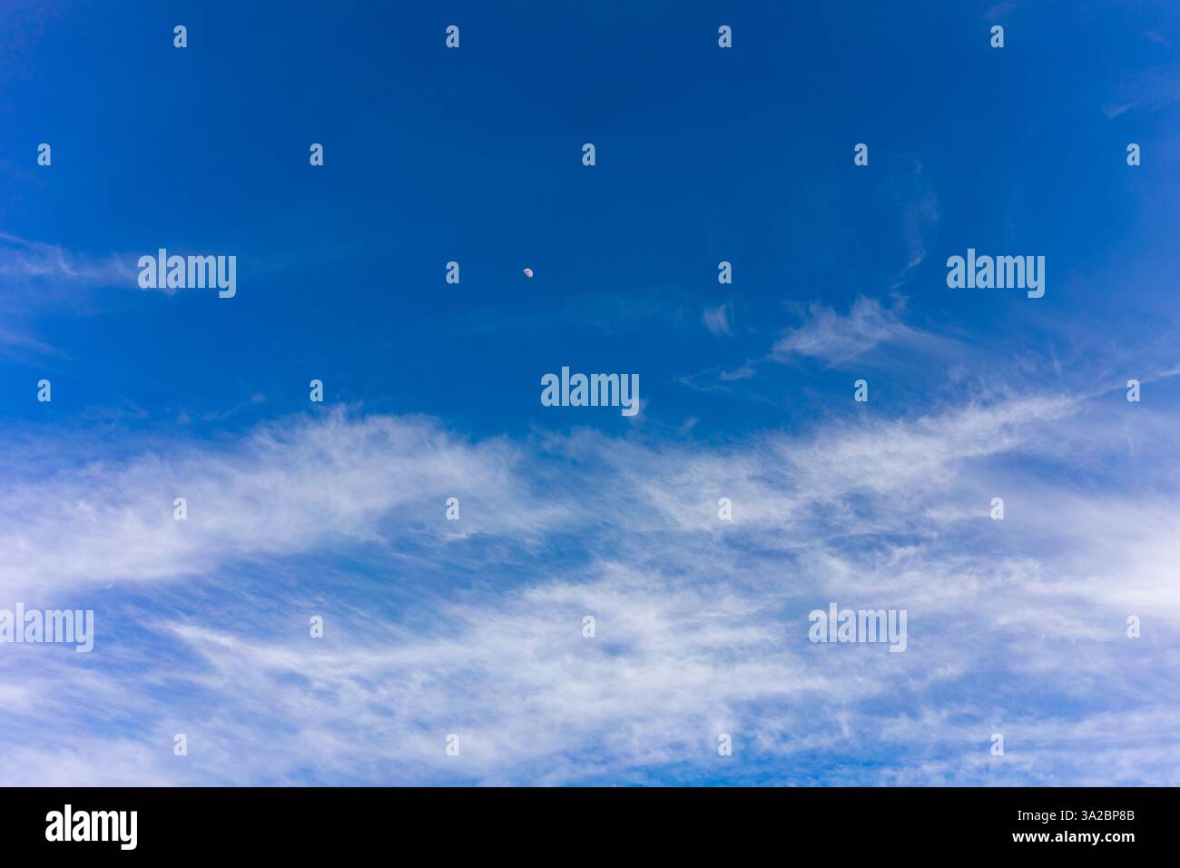 A serene sky showcases soft wispy clouds against a bright blue backdrop ...