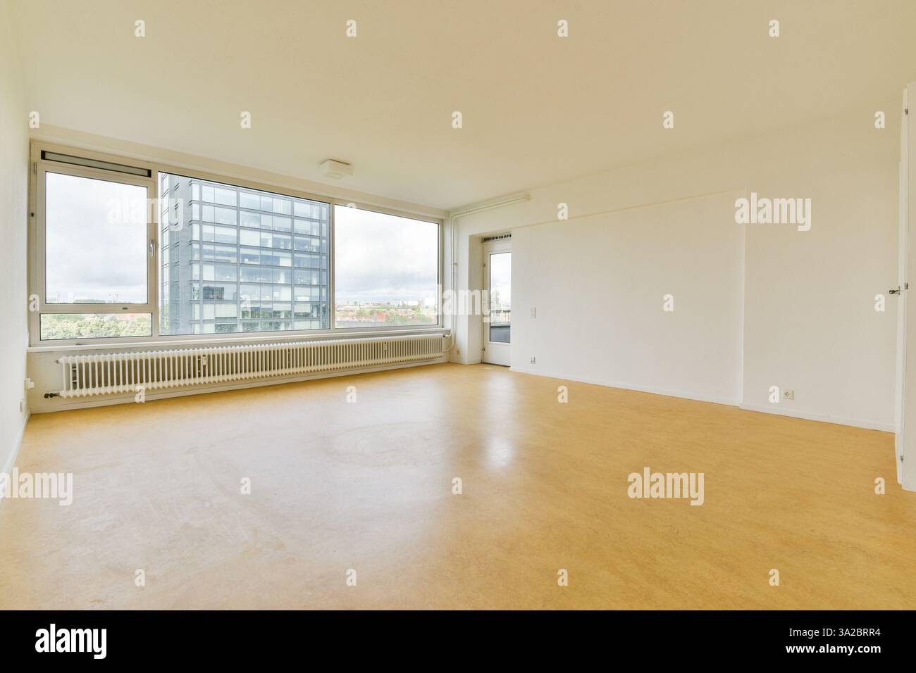 A spacious empty room featuring large windows that allow ample natural ...