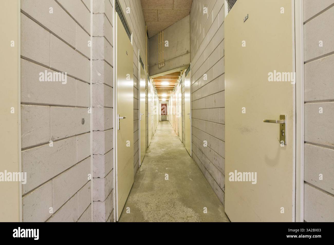 A spacious corridor lined with doors leading to individual rooms ...