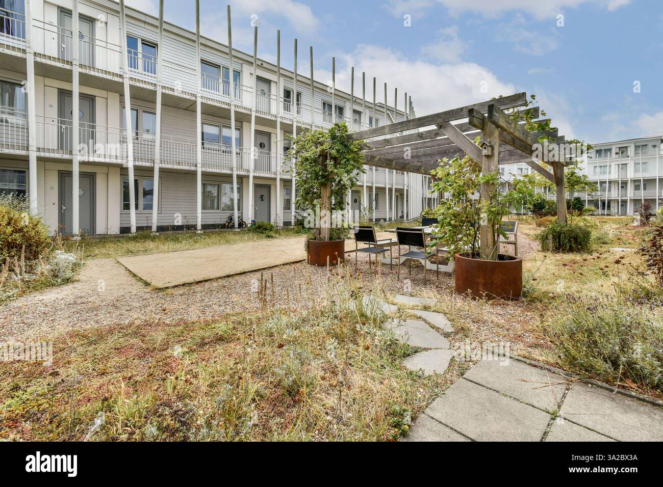 A modern residential building featuring green landscaping, outdoor ...