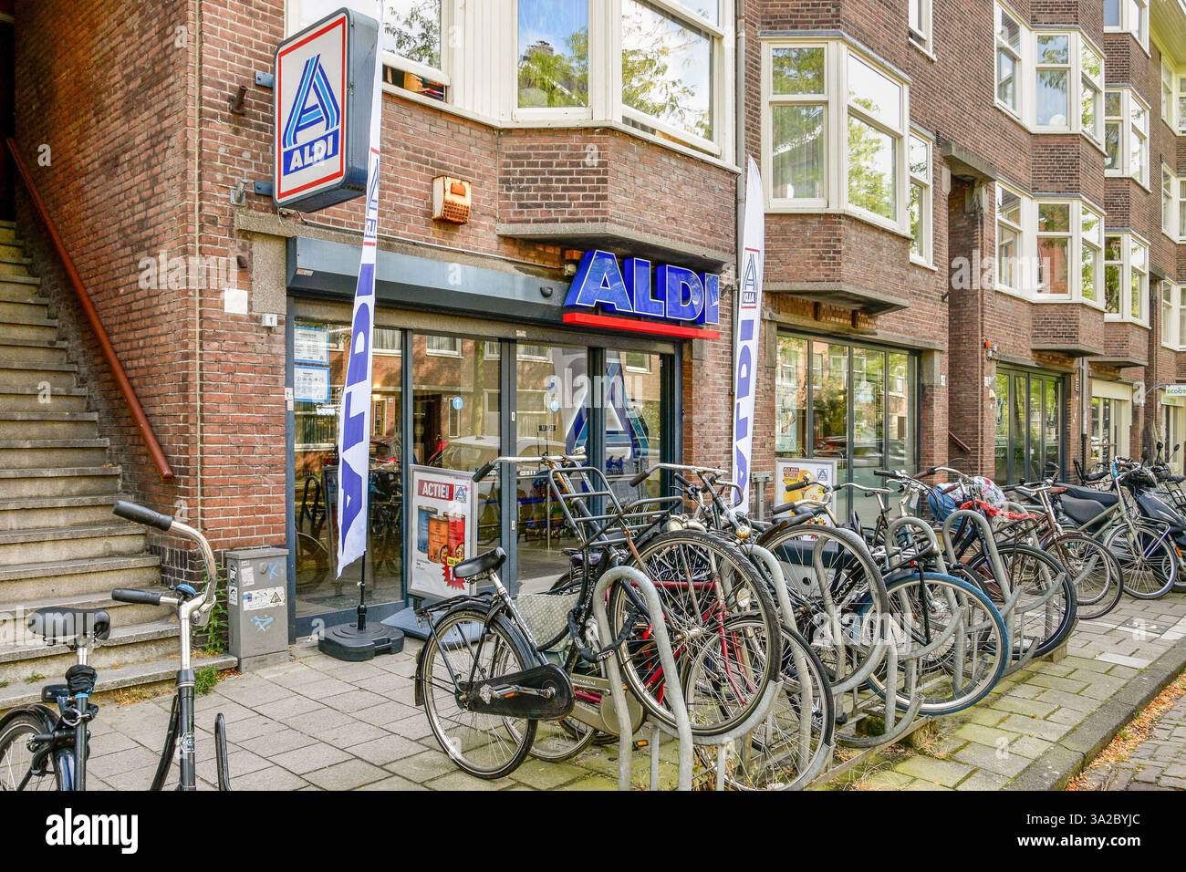 The image showcases an Aldi supermarket entrance, surrounded by parked ...
