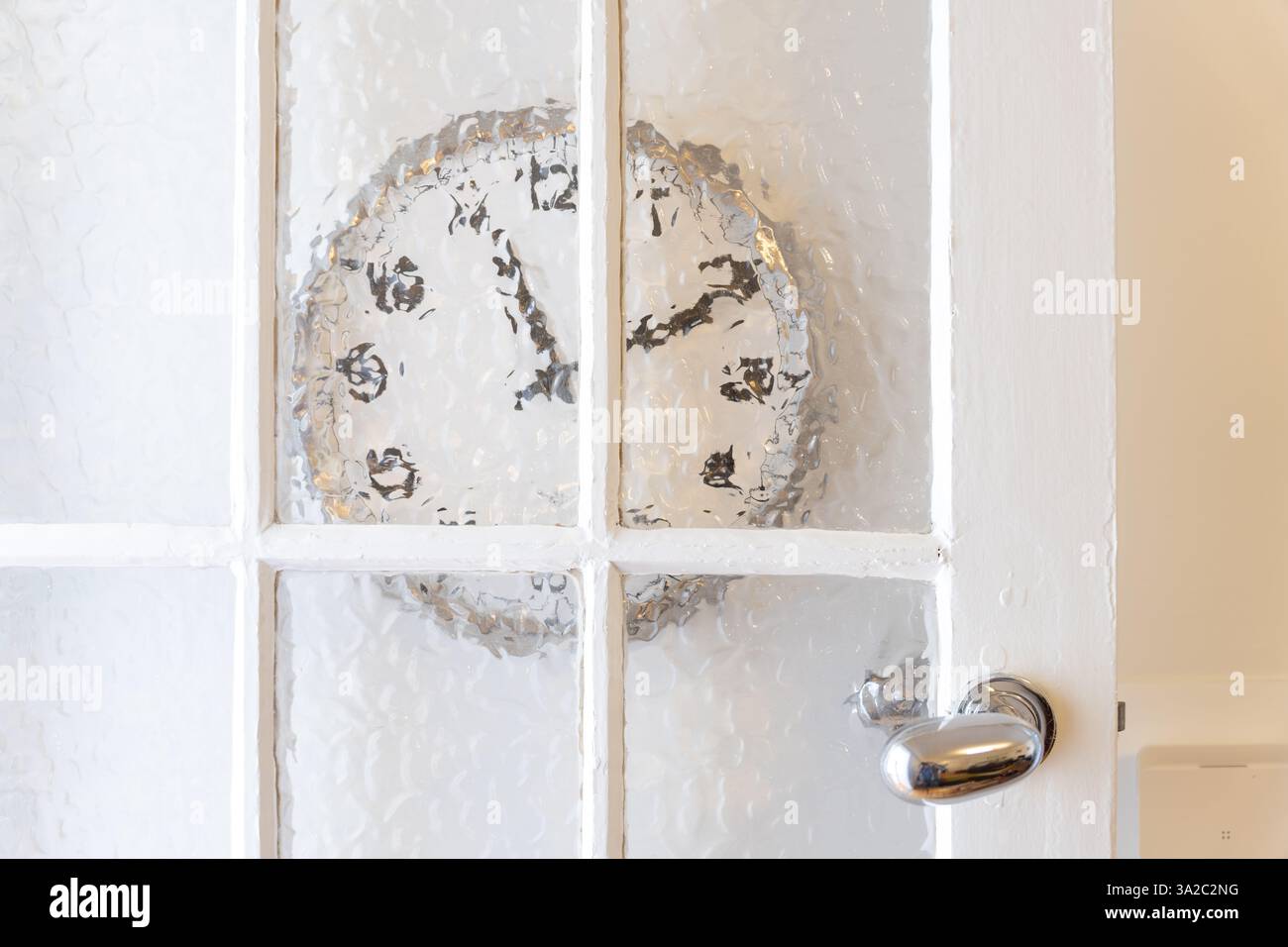 Analogue clock behind glass door Stock Photo - Alamy
