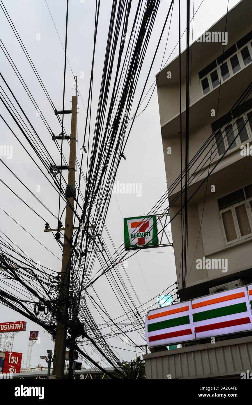 A mess of tangled wires and cables attached to a telegraph pole outside ...