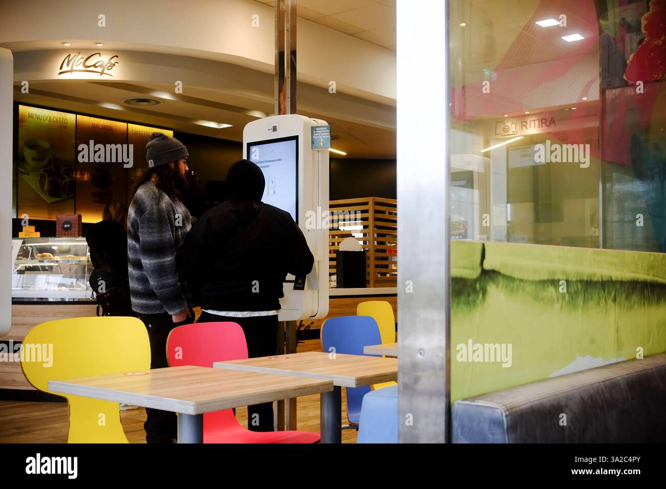 Lombardy, Italy March 1st 2025 Customers selecting food order at modern McDonald's self service ...