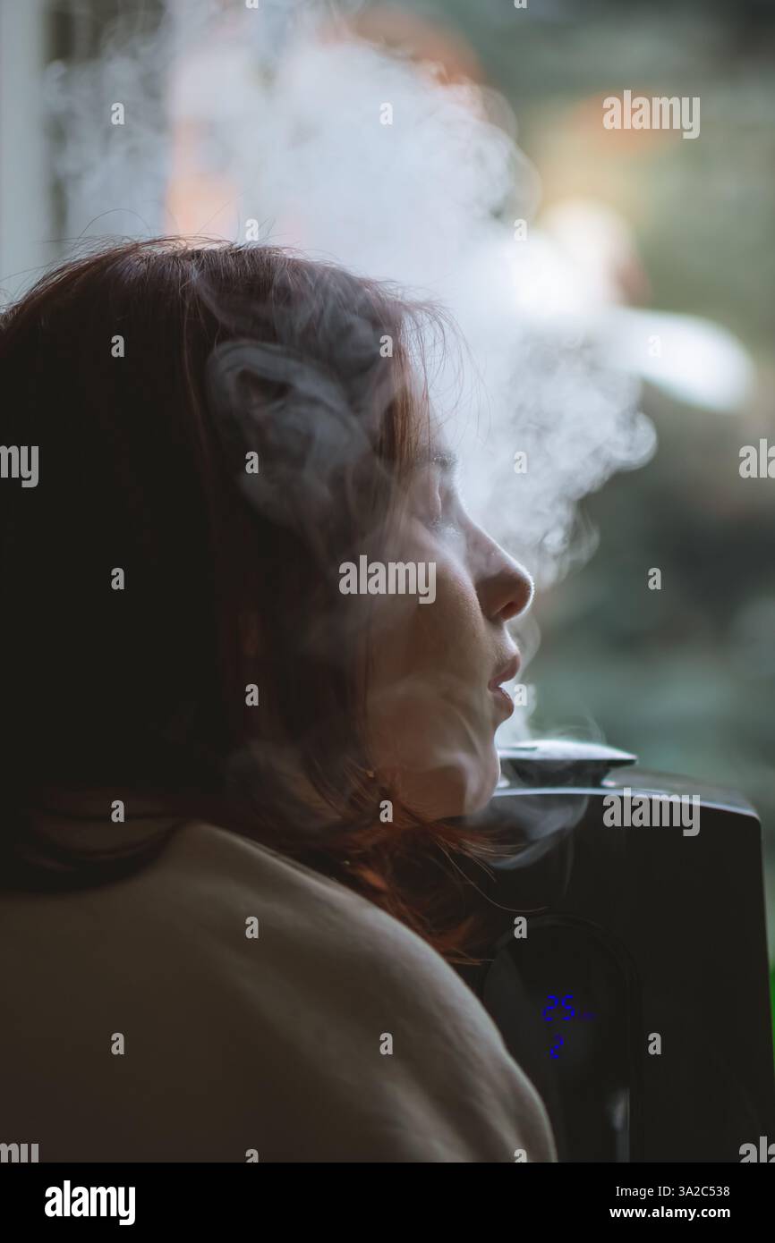 cute teen girl enjoys the benefits of a humidifier, breathing clean and ...