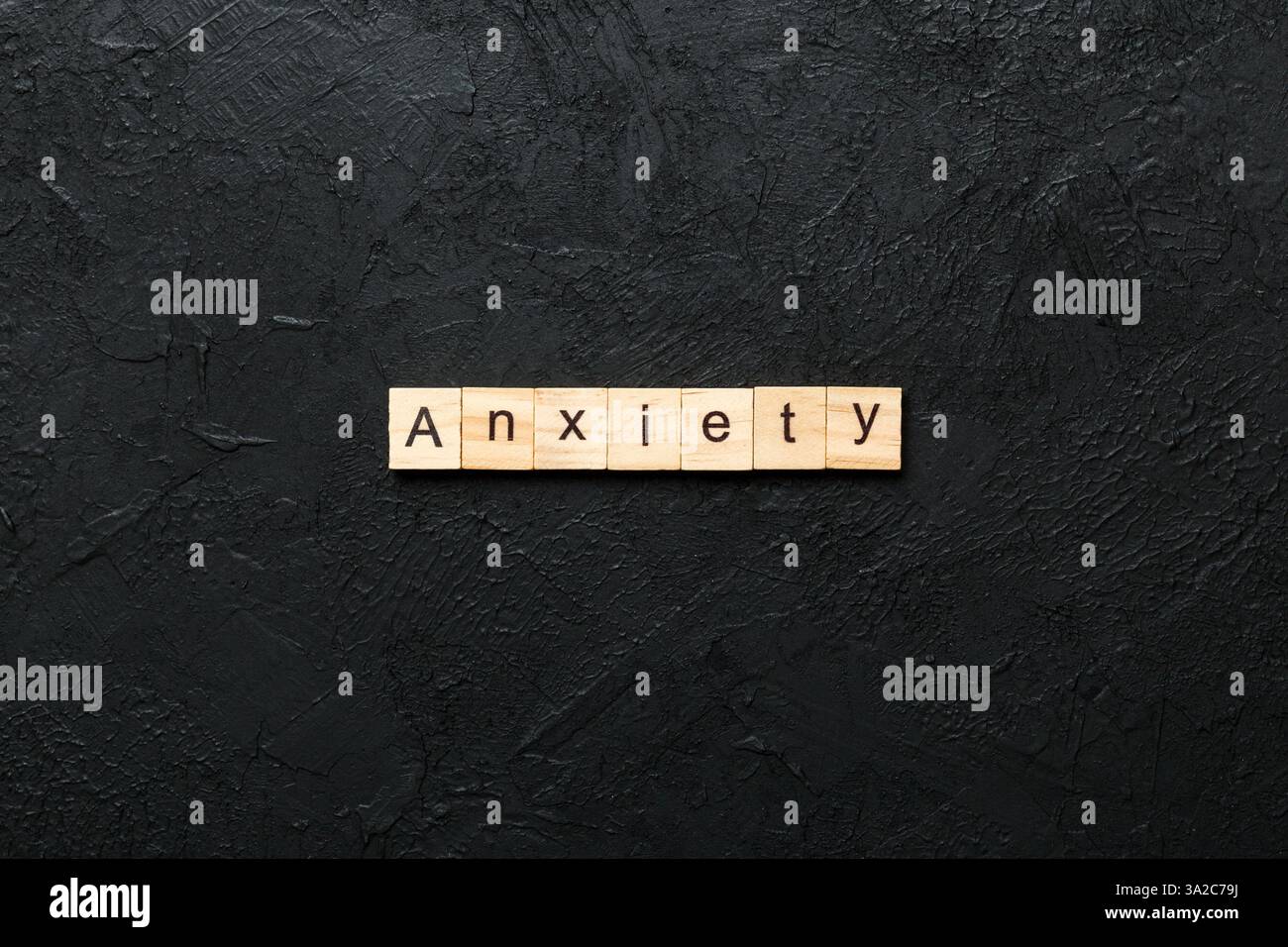 ANXIETY word written on wood block. ANXIETY text on table, concept ...