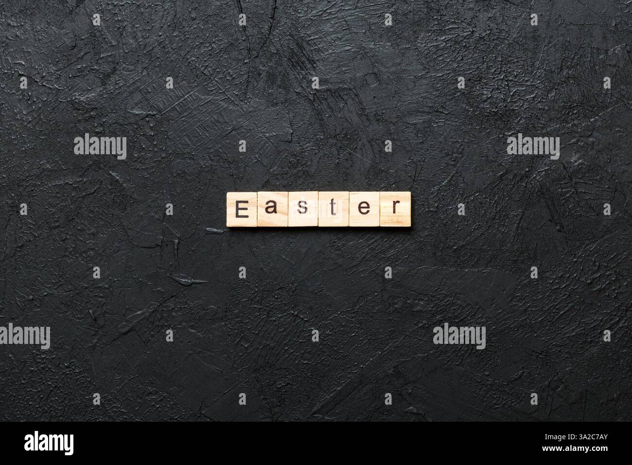 Easter word written on wood block. Easter text on cement table for your ...