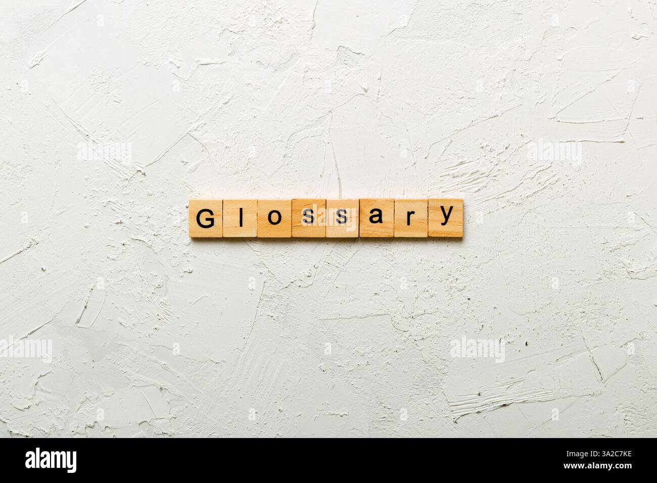 Glossary word written on wood block. Glossary text on cement table for ...
