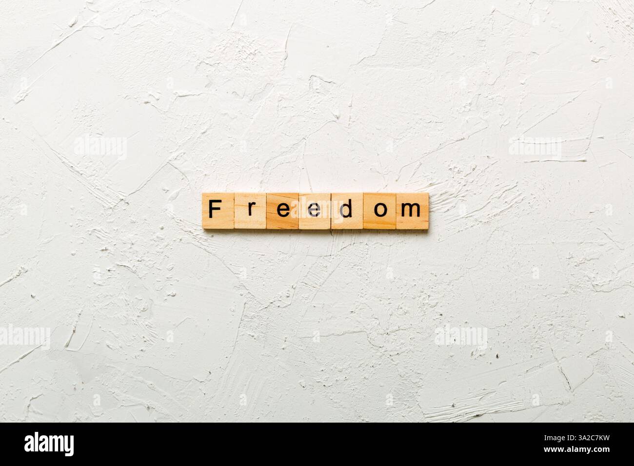 Freedom word written on wood block. Freedom text on cement table for ...