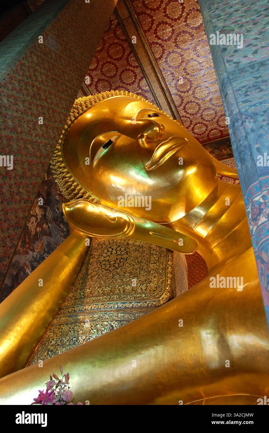 The Reclining Buddha at Wat Pho, Bangkok. This massive golden statue, 46 meters long, represents ...