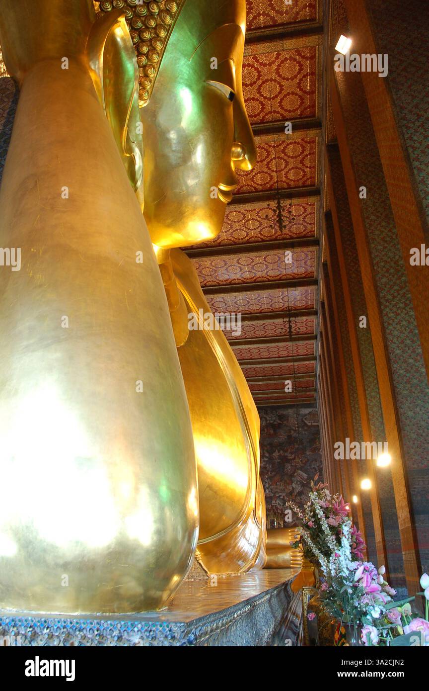The Reclining Buddha at Wat Pho, Bangkok. This massive golden statue, 46 meters long, represents ...