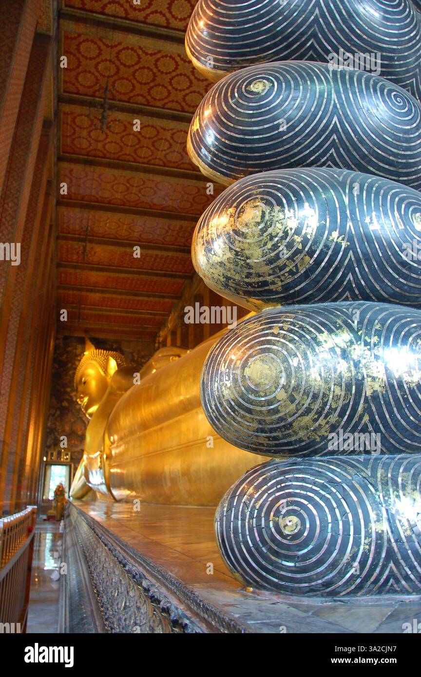 The Reclining Buddha at Wat Pho, Bangkok. This massive golden statue, 46 meters long, represents ...