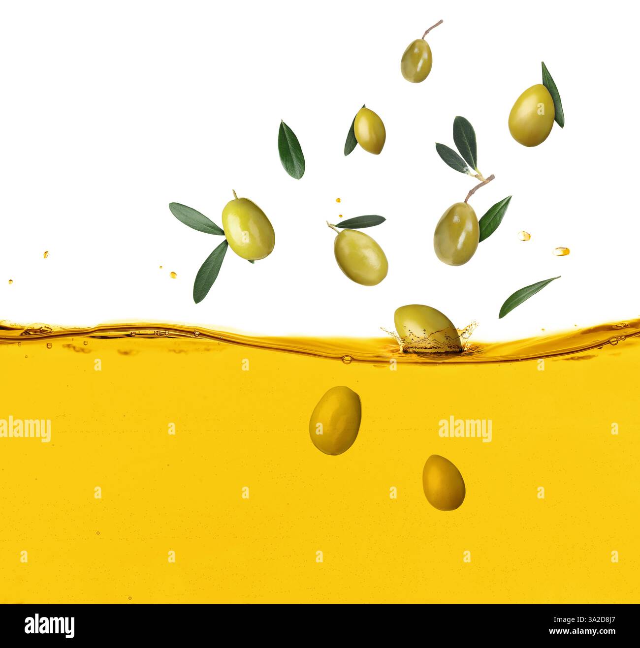 Green olives and leaves falling into cooking oil on white background ...