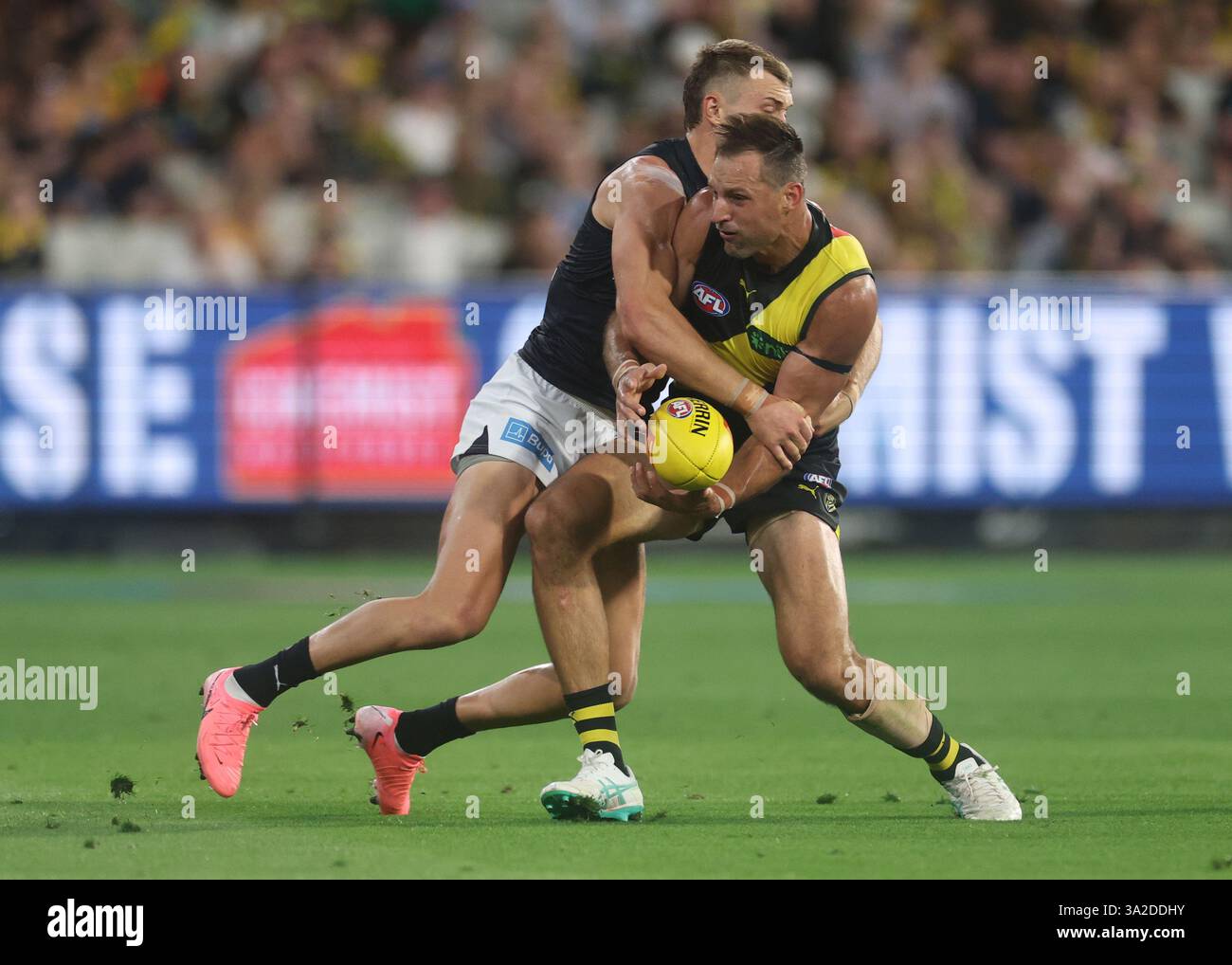 Toby Nankervis of the Tigers is tackled by Patrick Cripps of the Blues ...