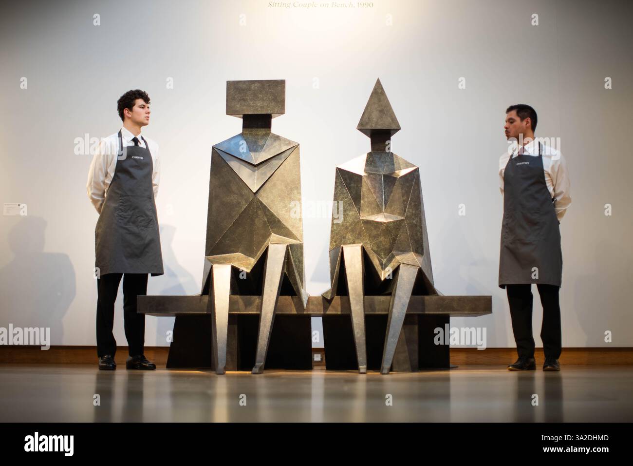 Art handlers stand near Lynn Chadwick's 'Sitting Couple on Bench ...
