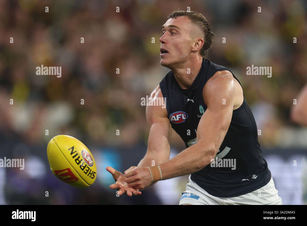 Patrick Cripps of the Blues handballs during the AFL Round 1 match ...