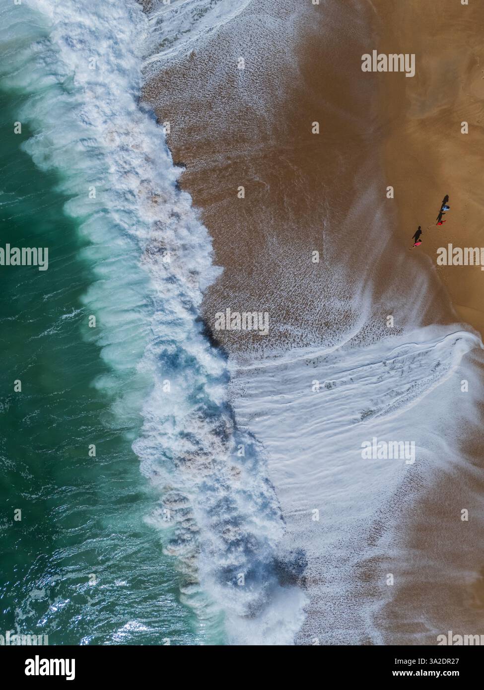Aerial view of the waves reaching the shore of Nazare beach, Portugal ...