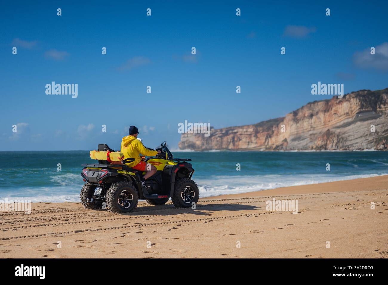 Lifeguard on quad watching Nazare beach with red flag, Portugal Stock ...