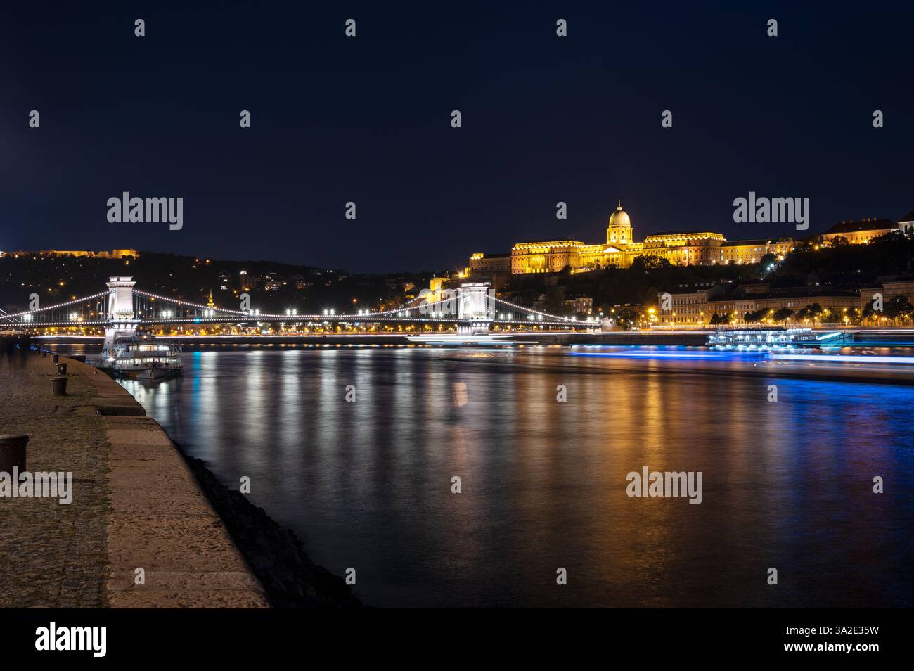 Illuminated night view of the chain bridge, the Buda castle, and the Danube river in Budapest ...