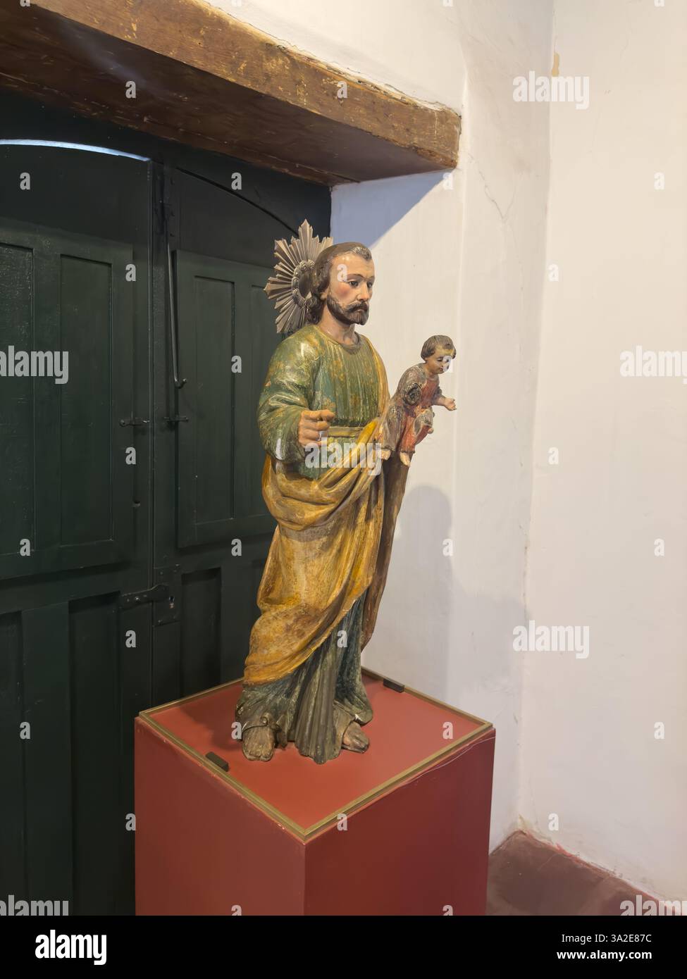 An antique carved and painted wooden statue of St. Joseph with the baby ...