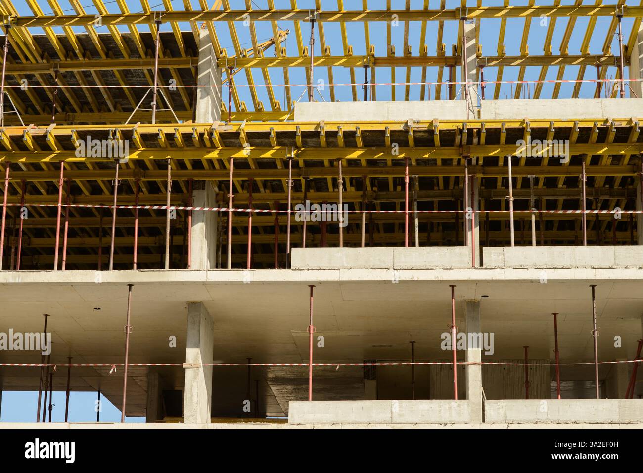 A multi-level concrete structure in progress, showcasing yellow ...
