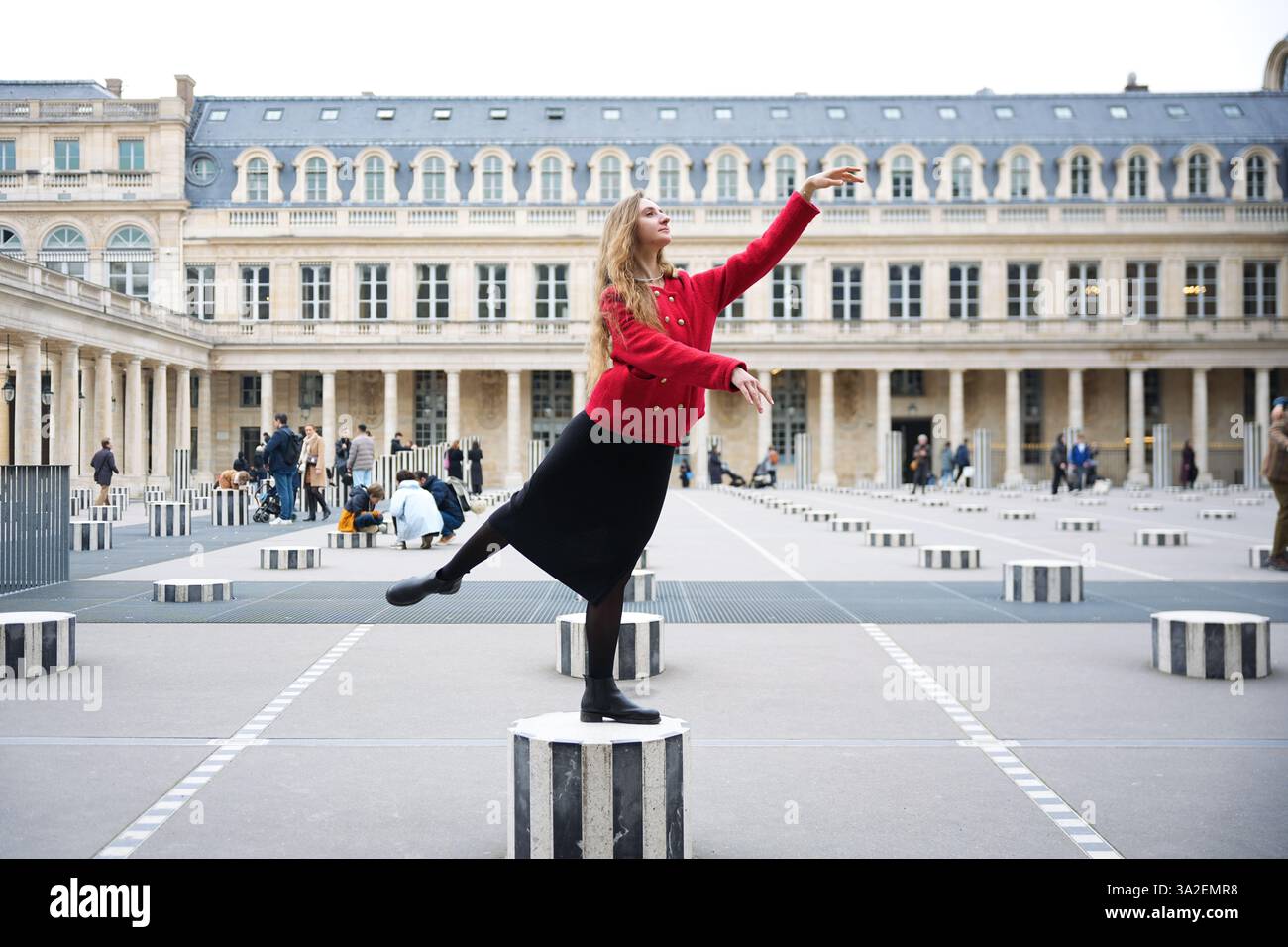 Paris, France 03.10.2025 A graceful woman in a red coat and black dress ...